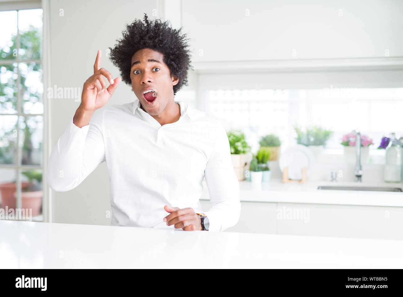 African American man pointing finger up with successful idea. Exited ...