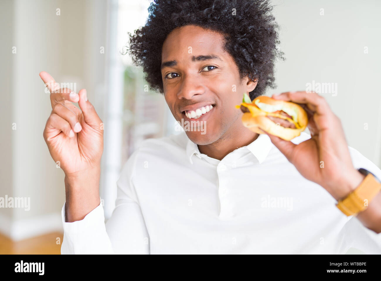 African American hungry man eating hamburger for lunch very happy ...