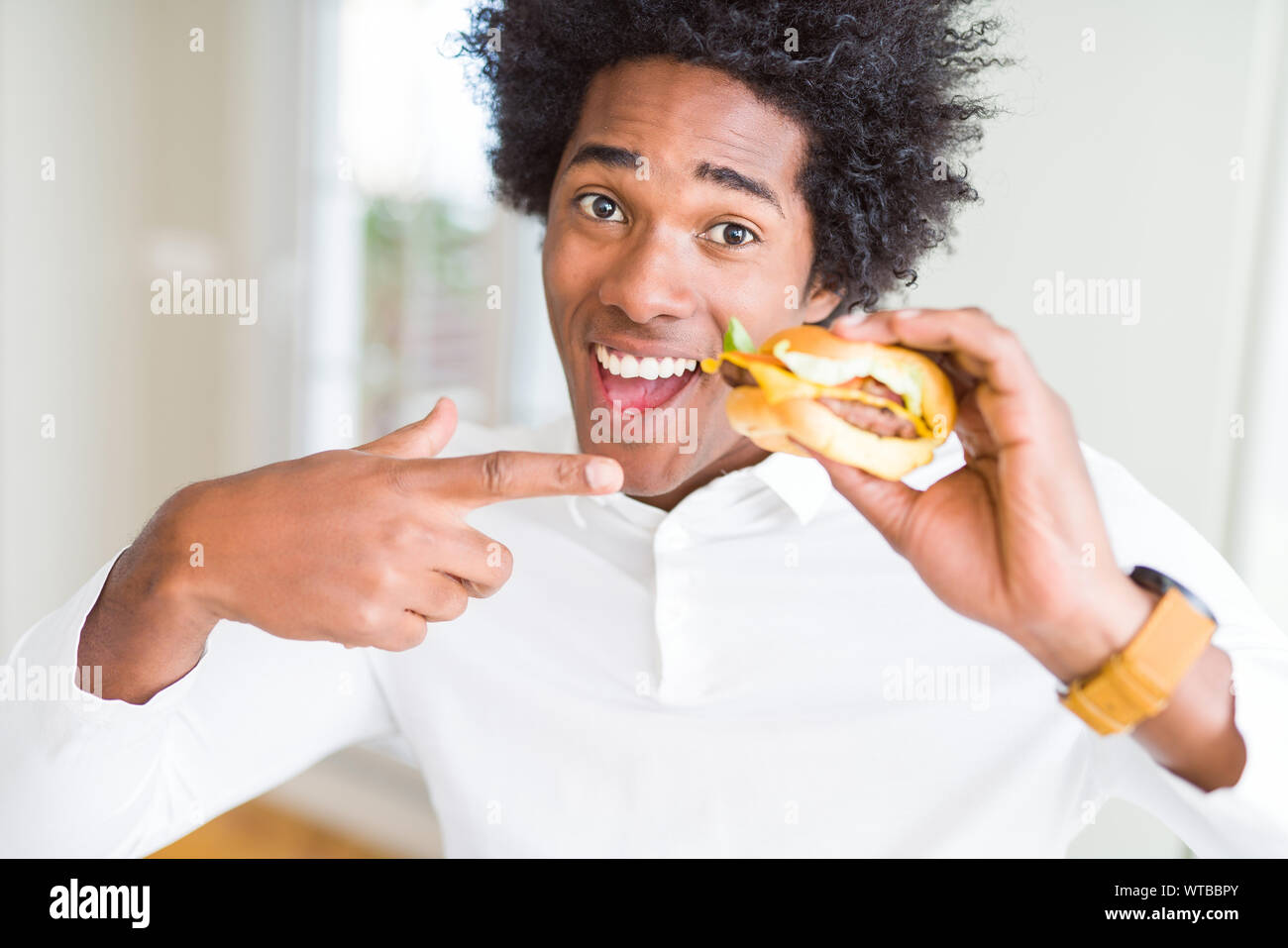 African American hungry man eating hamburger for lunch very happy ...