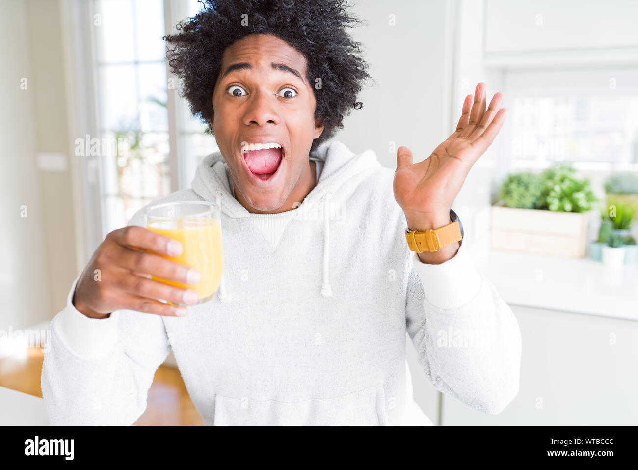 African American man holding and drinking glass of orange juice very ...