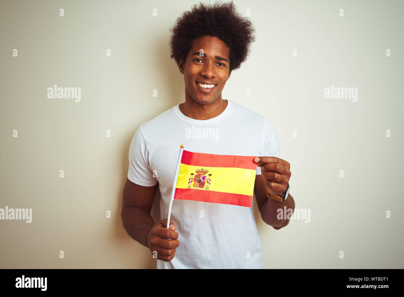 Young afro american man holding Spain Spanish flag standing over ...