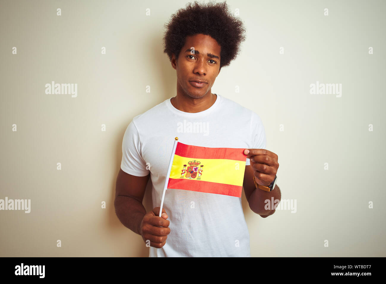 Young afro american man holding Spain Spanish flag standing over ...