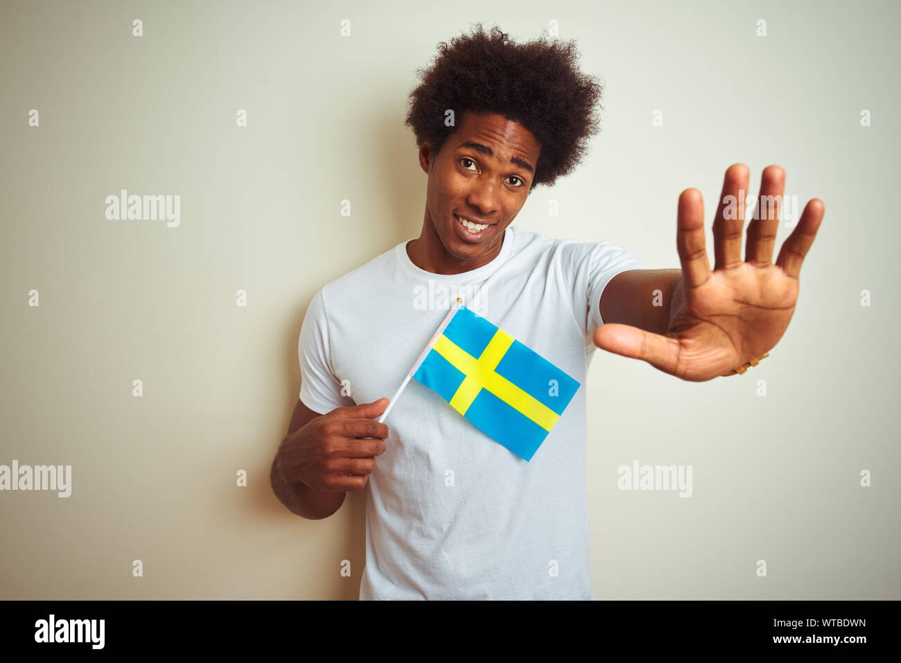 Young afro american man holding Sweden Swedish flag standing over ...