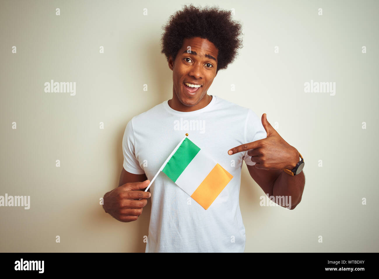 Young african american man holding Ireland Irish flag standing over ...
