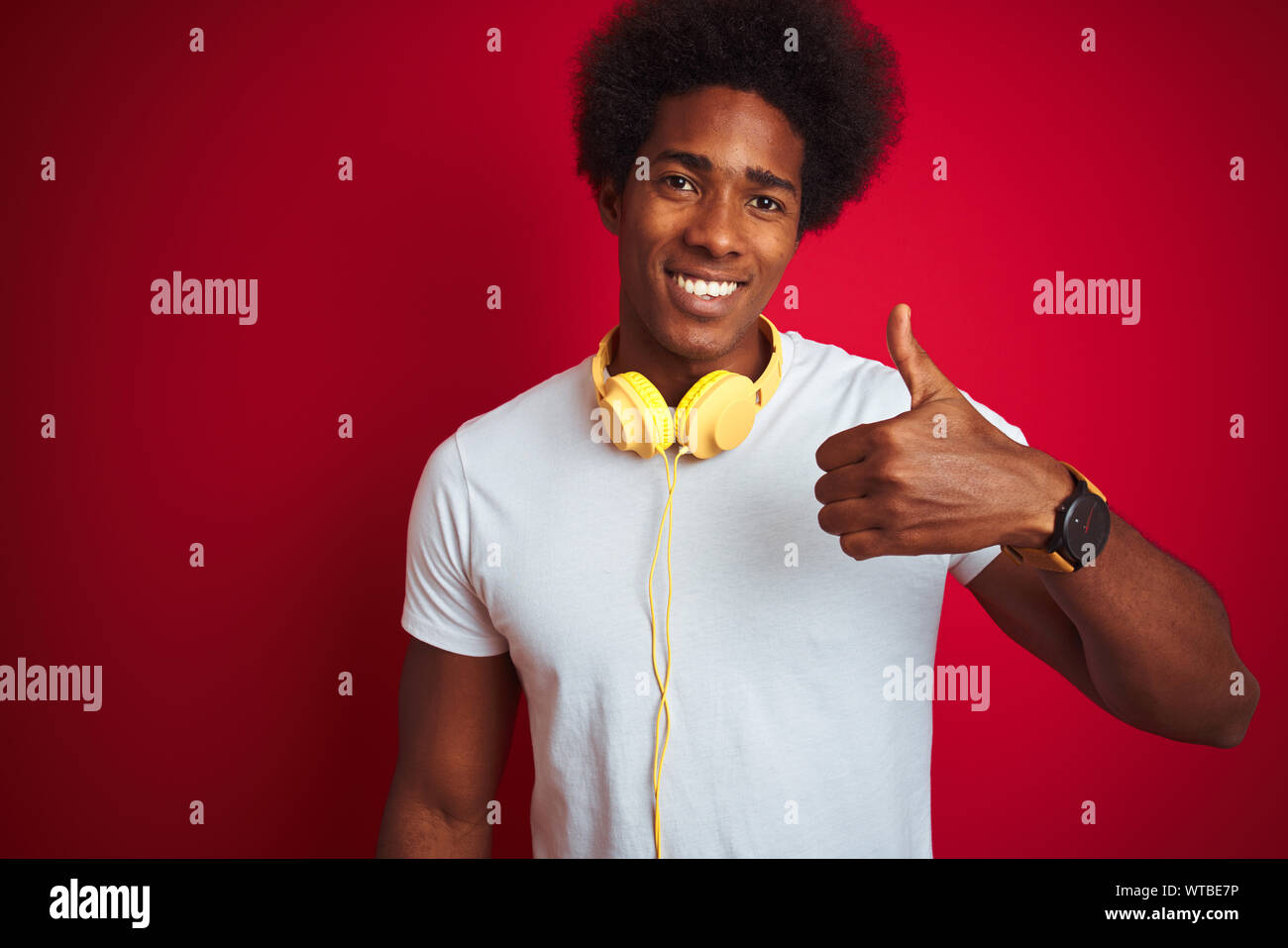 Young african american man listening to music using headphones over ...