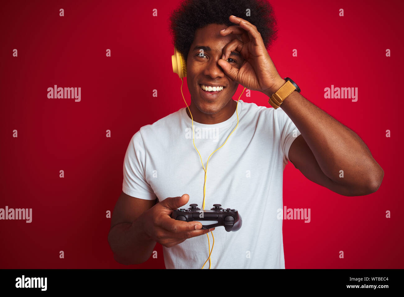 Afro gamer man playing video game using joystick headphones over ...