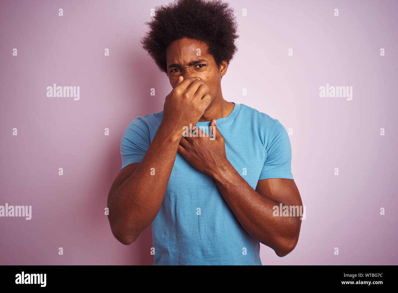 African american man with afro hair wearing blue t-shirt standing over ...