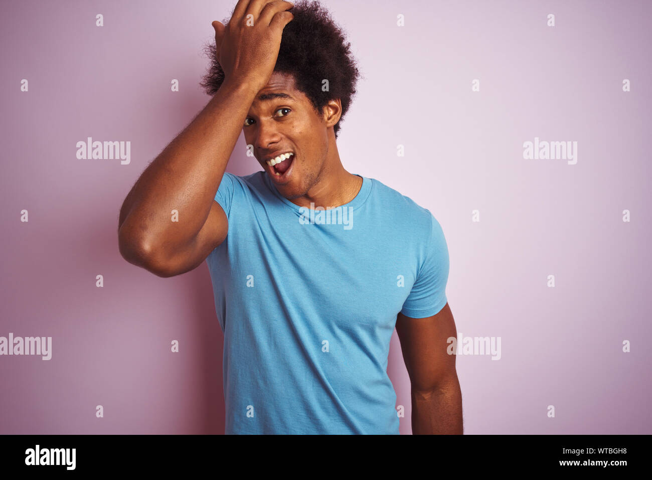 African american man with afro hair wearing blue t-shirt standing over ...