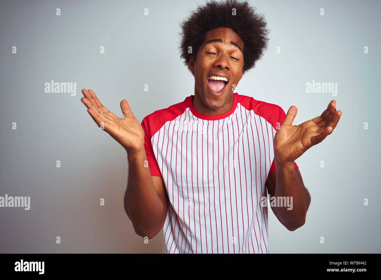 African american man with afro hair wearing red striped t-shirt over ...