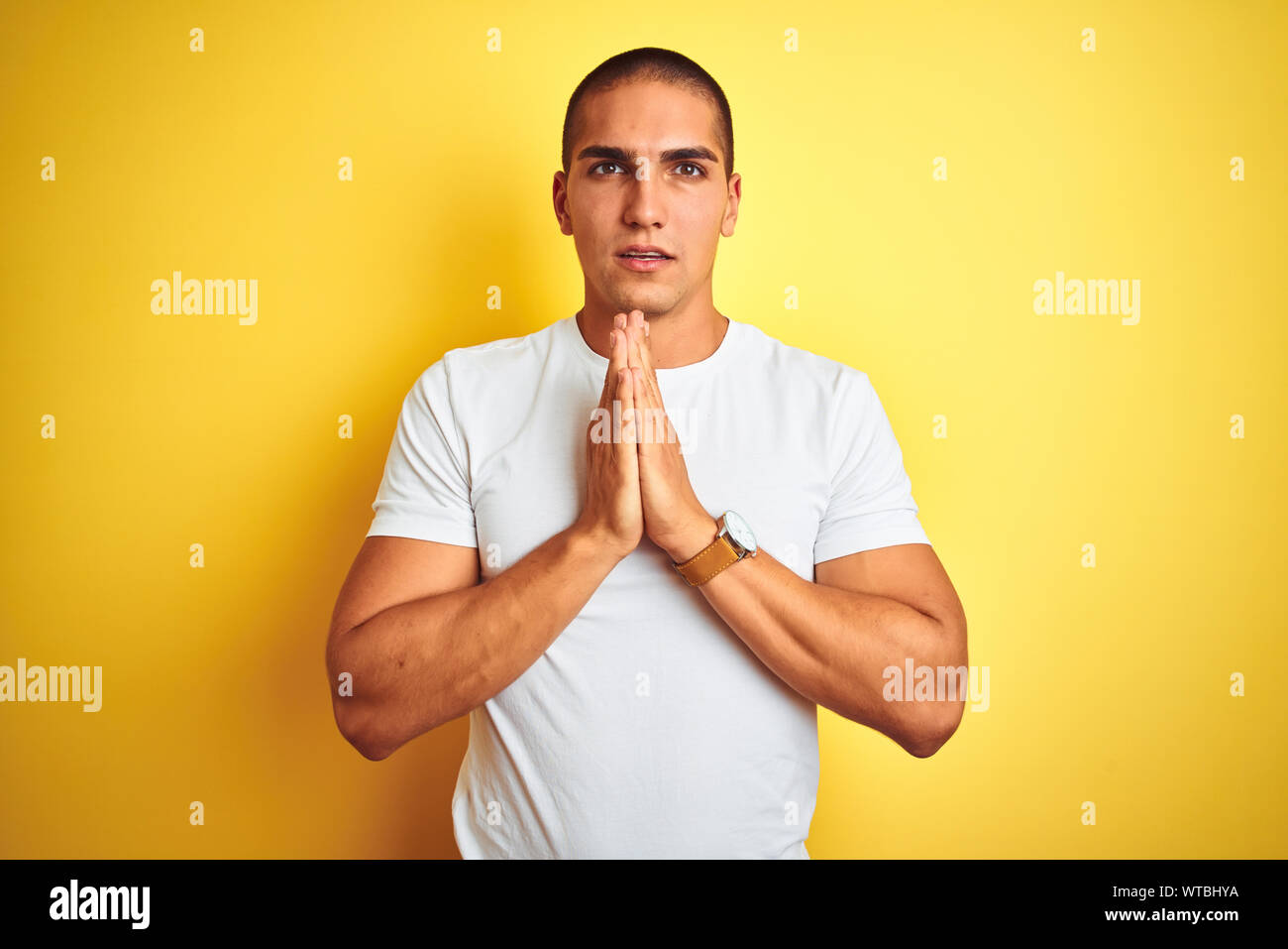 Young caucasian man wearing casual white t-shirt over yellow isolated ...