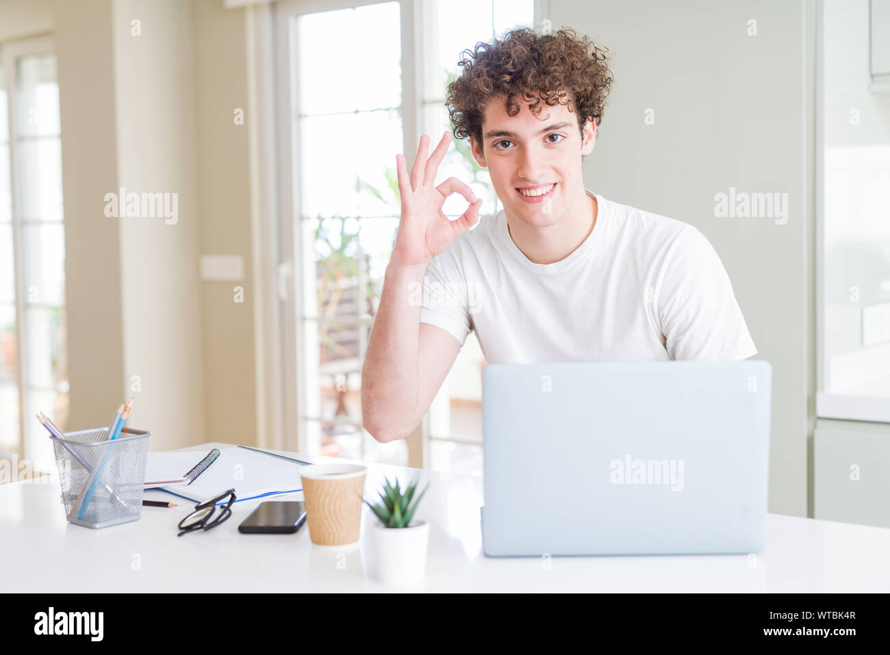 Young student man working and studying using computer laptop doing ok ...