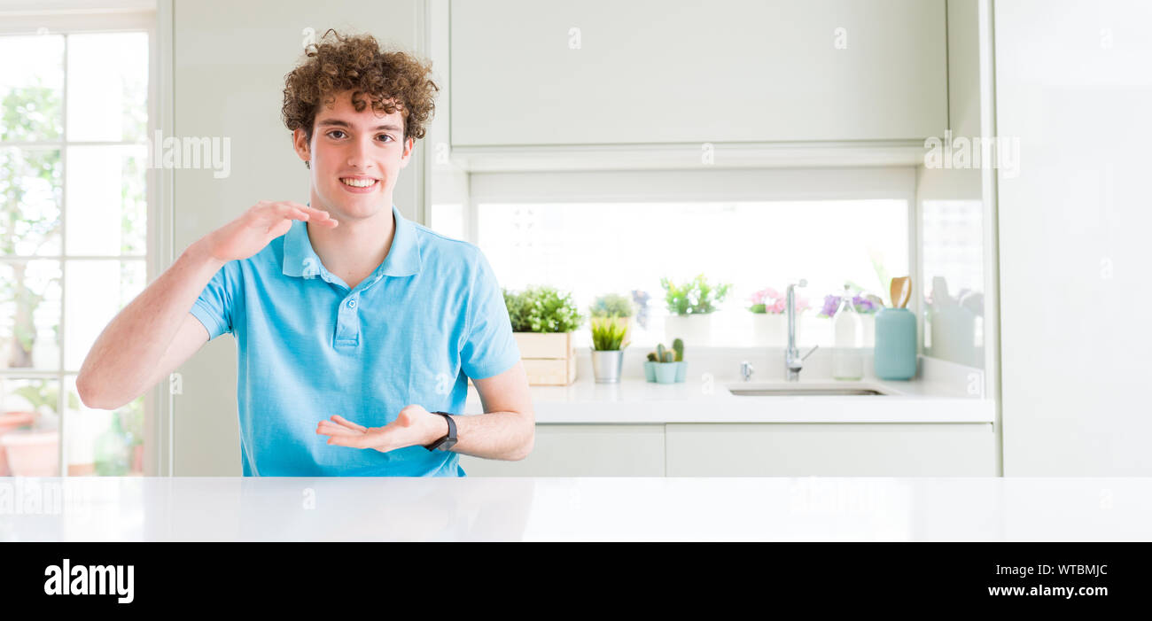 Wide shot of young handsome man at home gesturing with hands showing ...