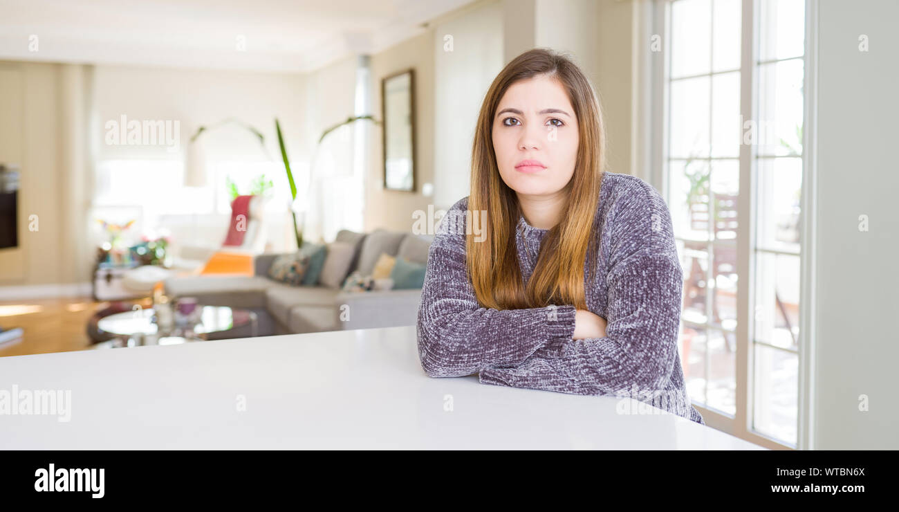 Beautiful young woman at home skeptic and nervous, disapproving ...
