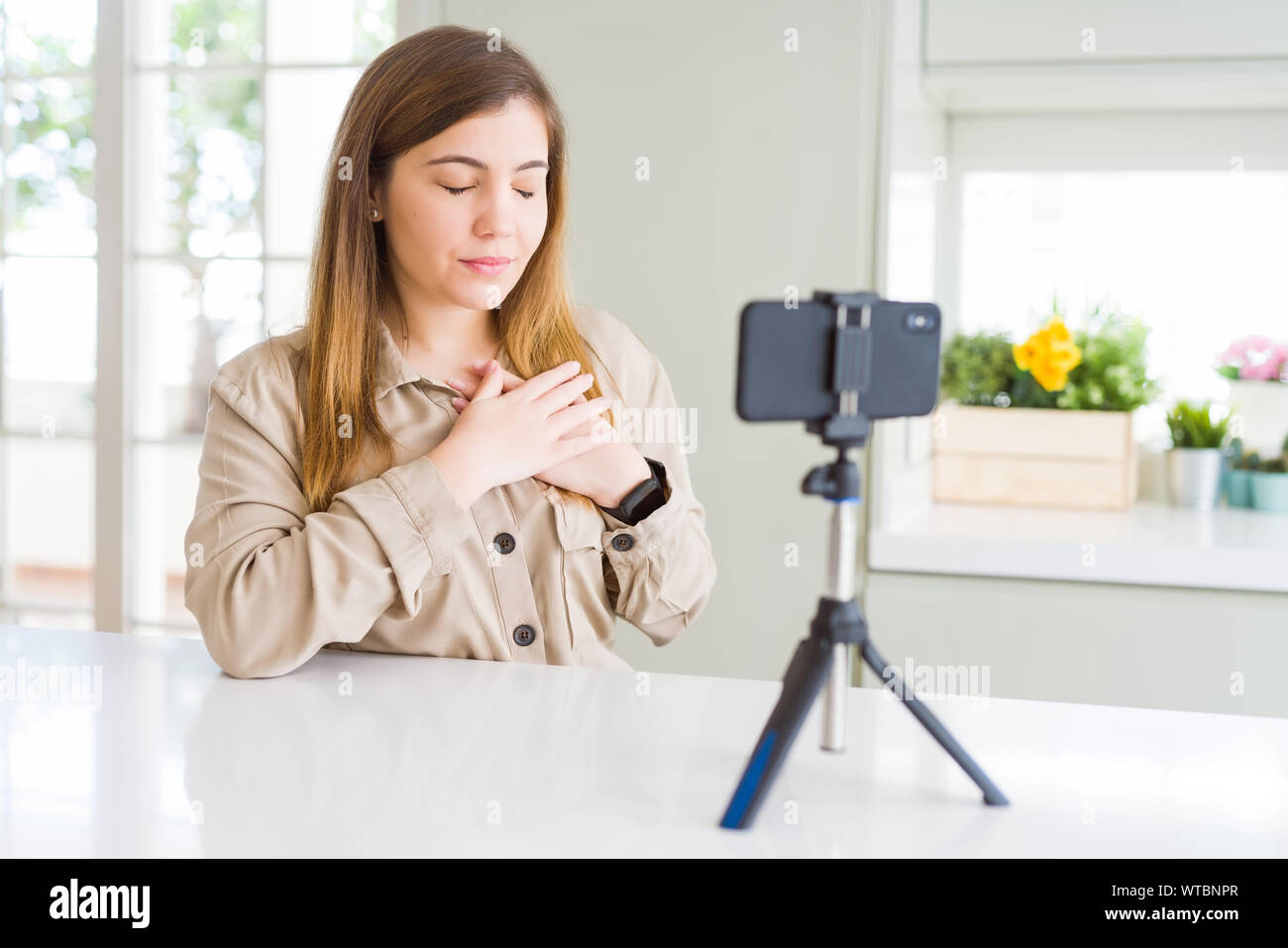 Beautiful young woman doing online video call using smartphone webcam ...