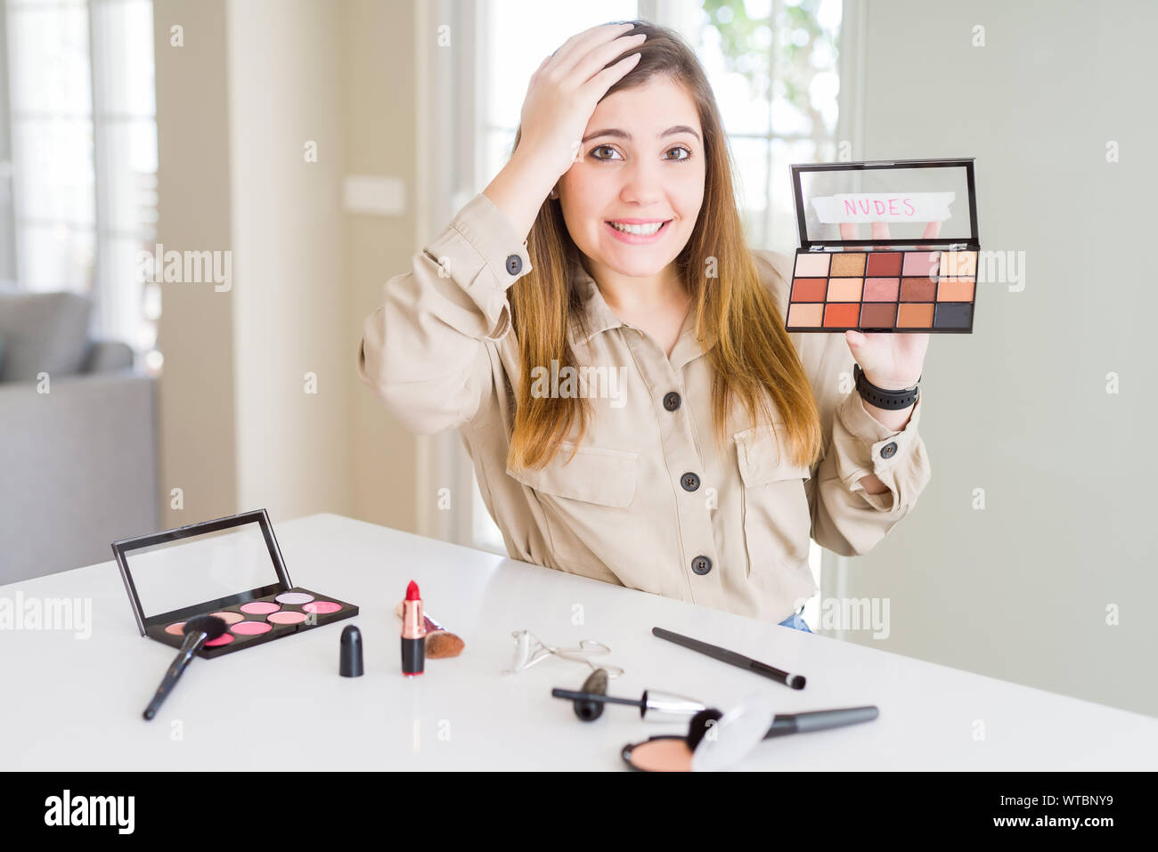 Beautiful young woman using make up cosmetics applying color from ...
