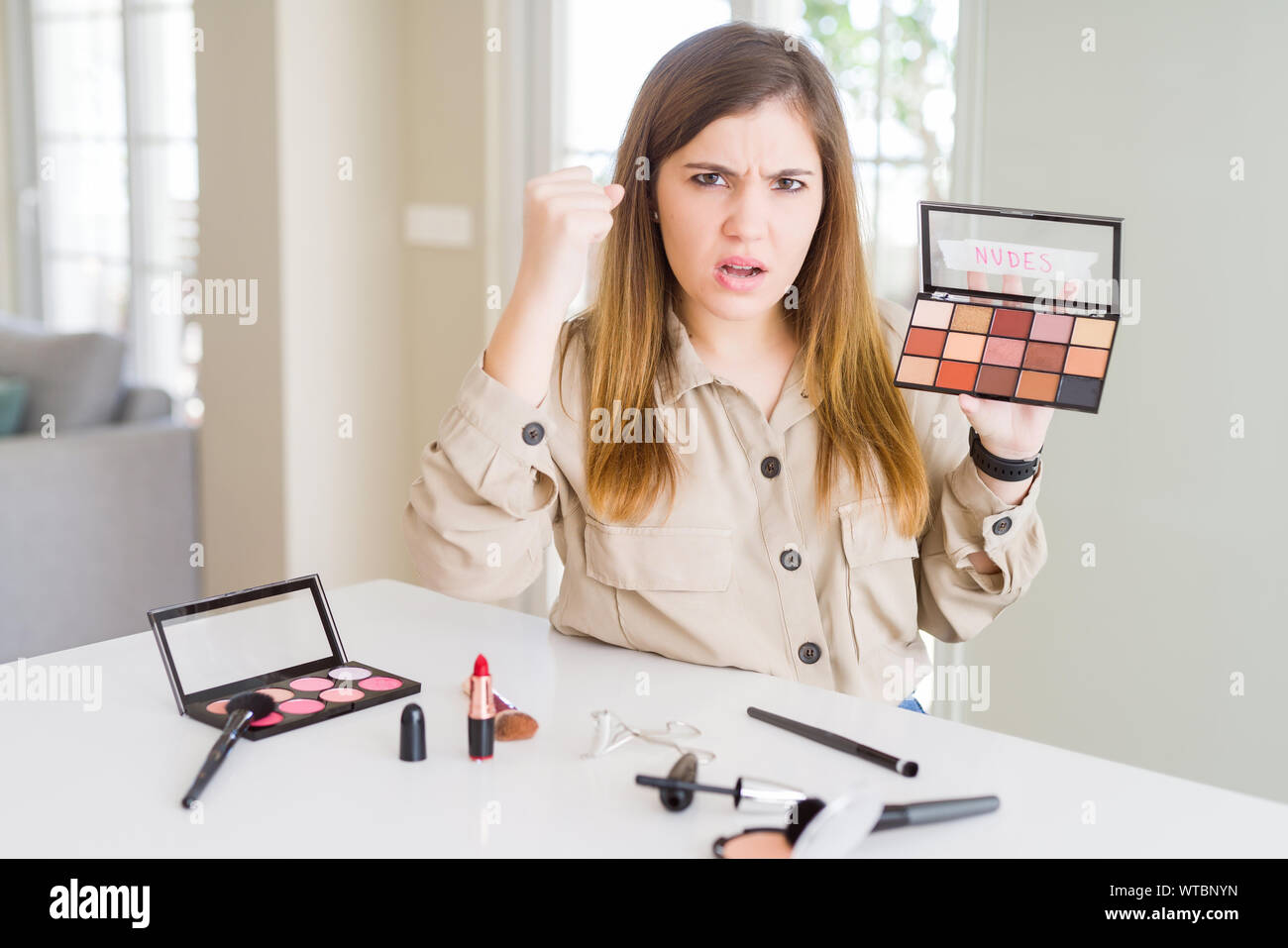 Beautiful young woman using make up cosmetics applying color from ...