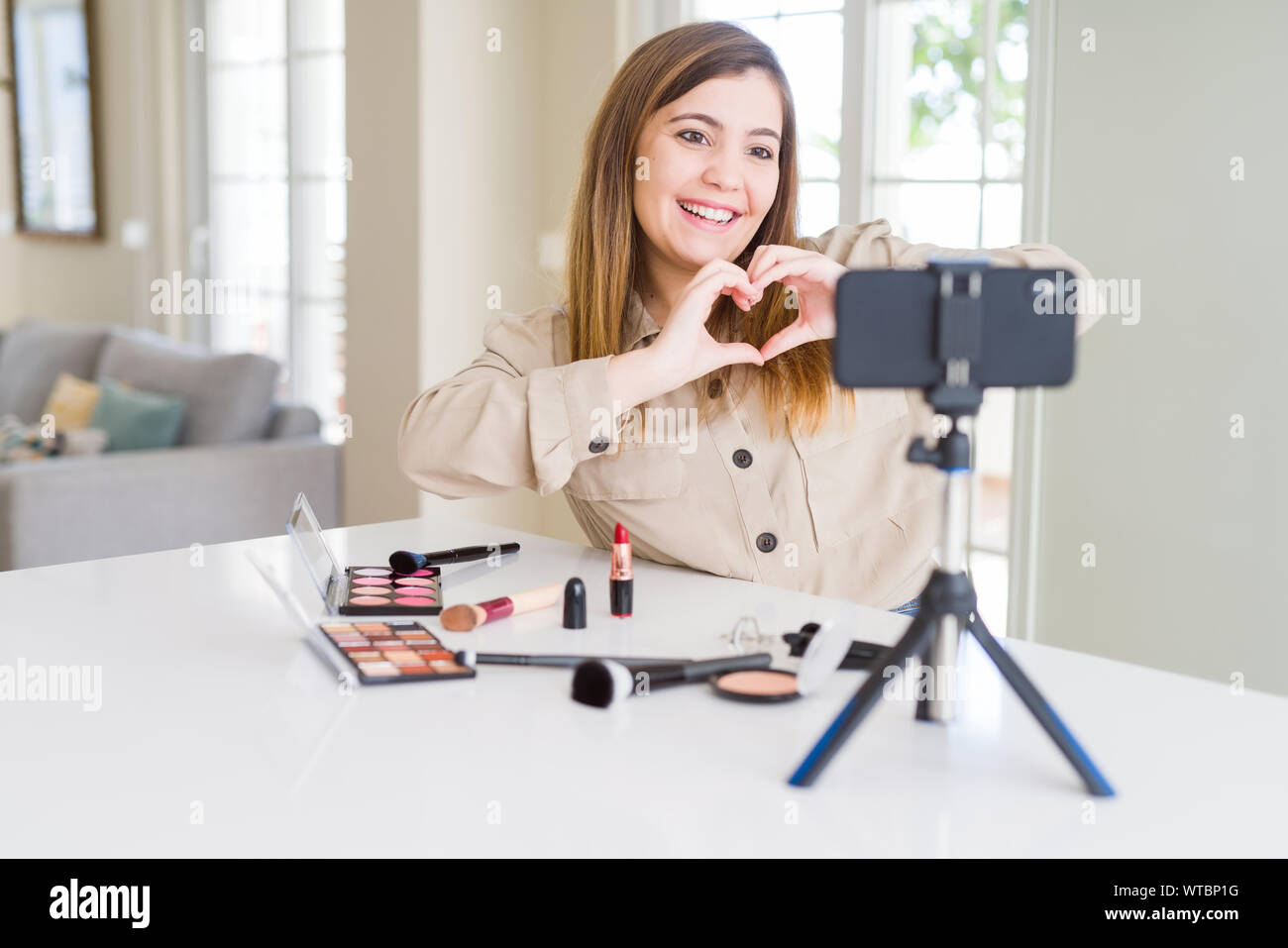 Beautiful young influencer woman recording make up video tutorial ...
