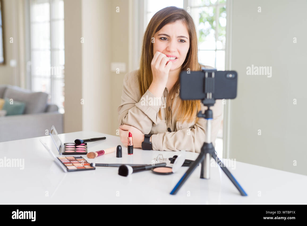 Beautiful young influencer woman recording make up video tutorial ...