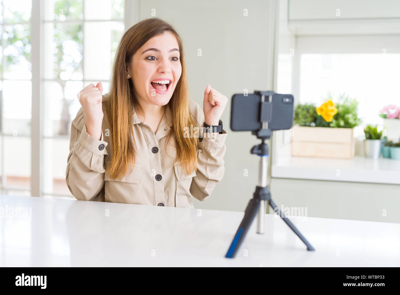 Beautiful young woman doing online video call using smartphone webcam ...