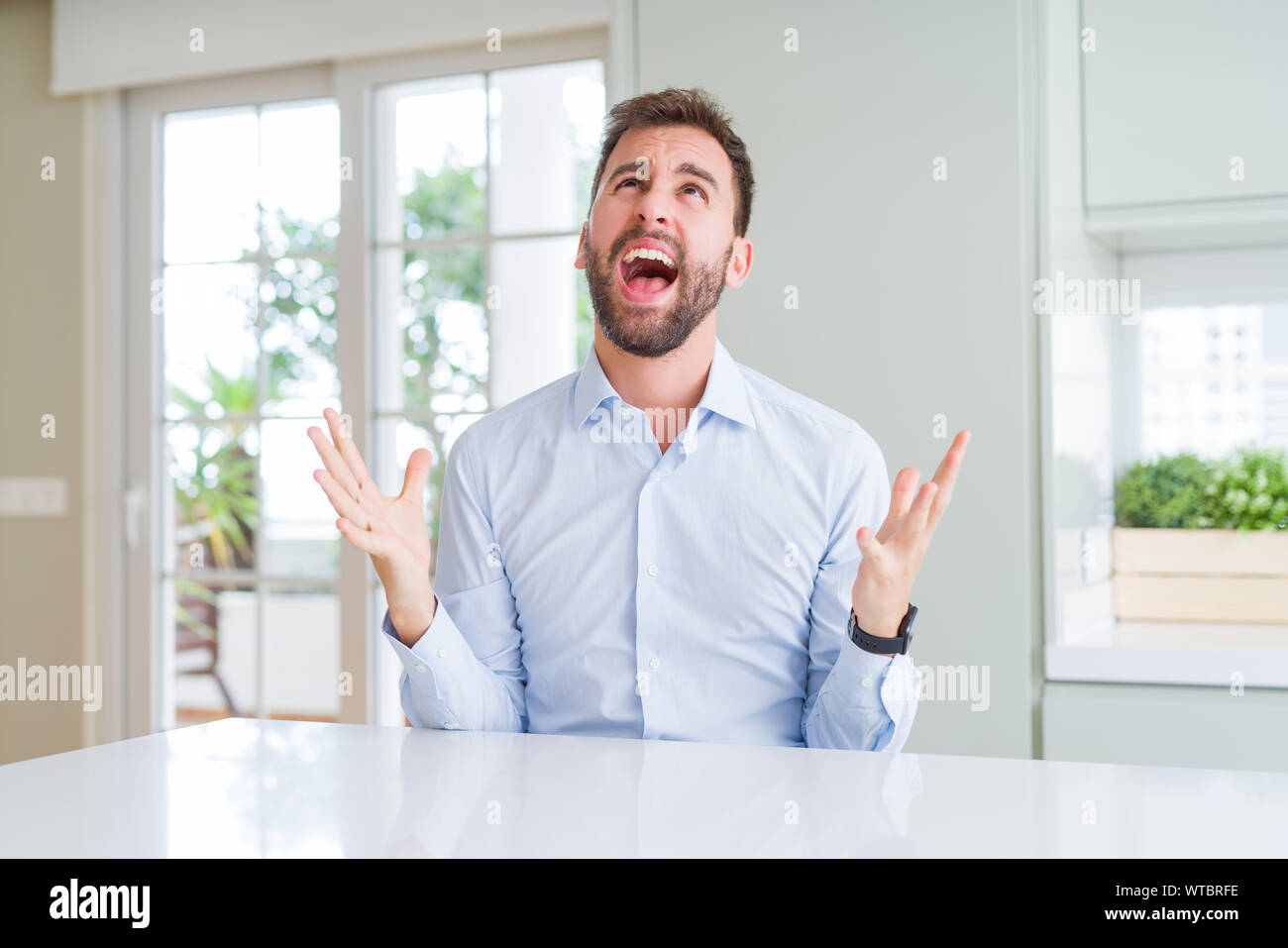 Handsome business man crazy and mad shouting and yelling with ...