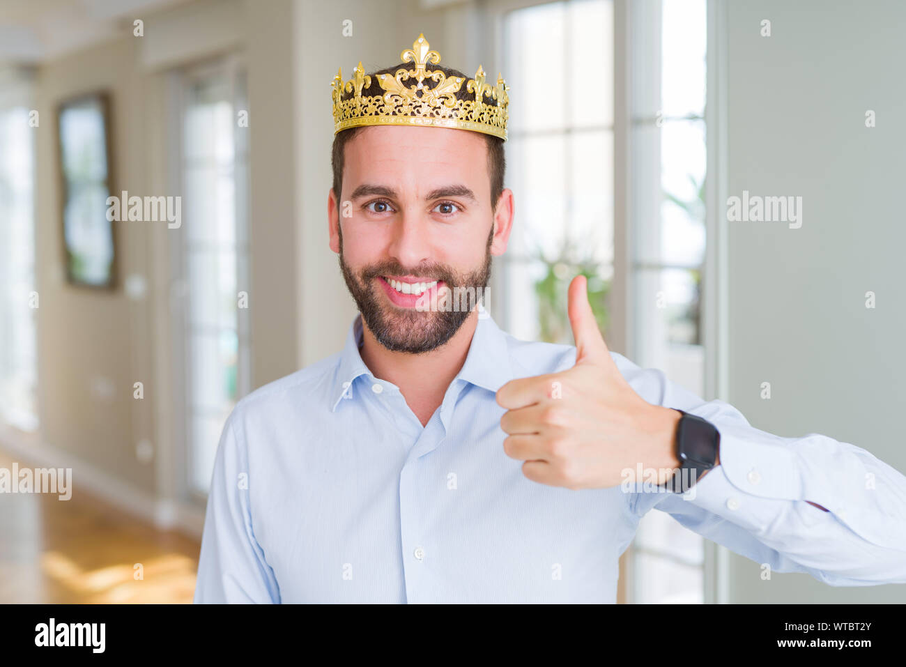 Handsome business man wearing golden crown as a king or prince doing ...