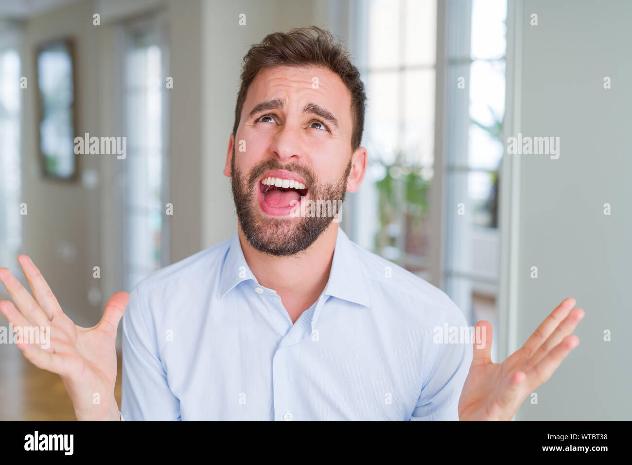 Handsome business man crazy and mad shouting and yelling with ...