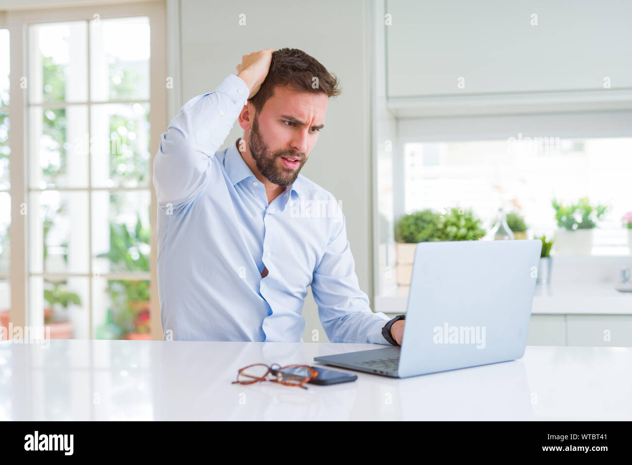 Handsome business man working using computer laptop stressed with hand ...