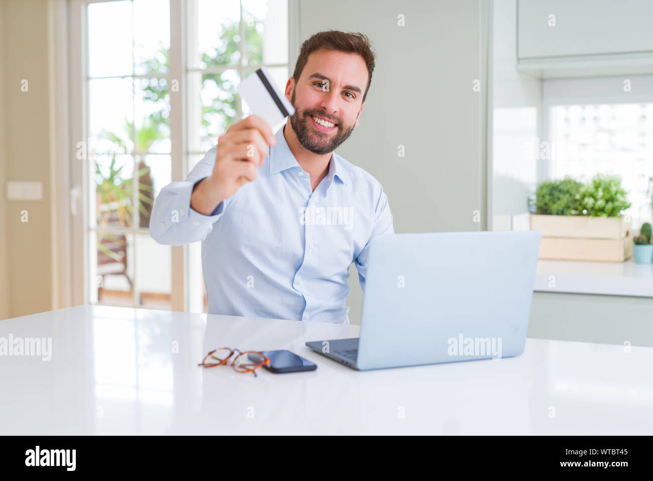 Handsome business man shopping online using computer laptop and credit ...