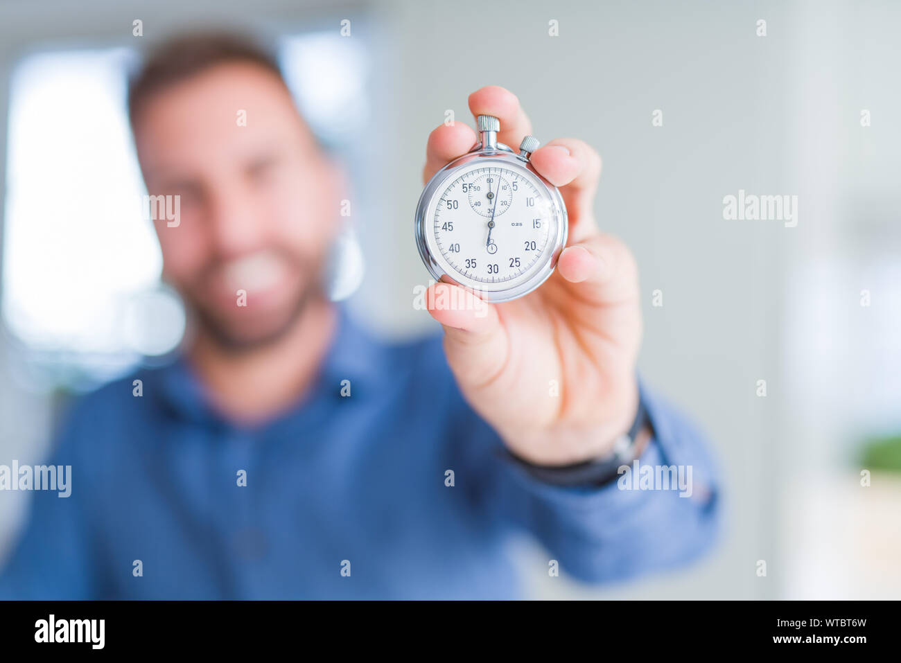 Handsome man showing stopwatch Stock Photo - Alamy