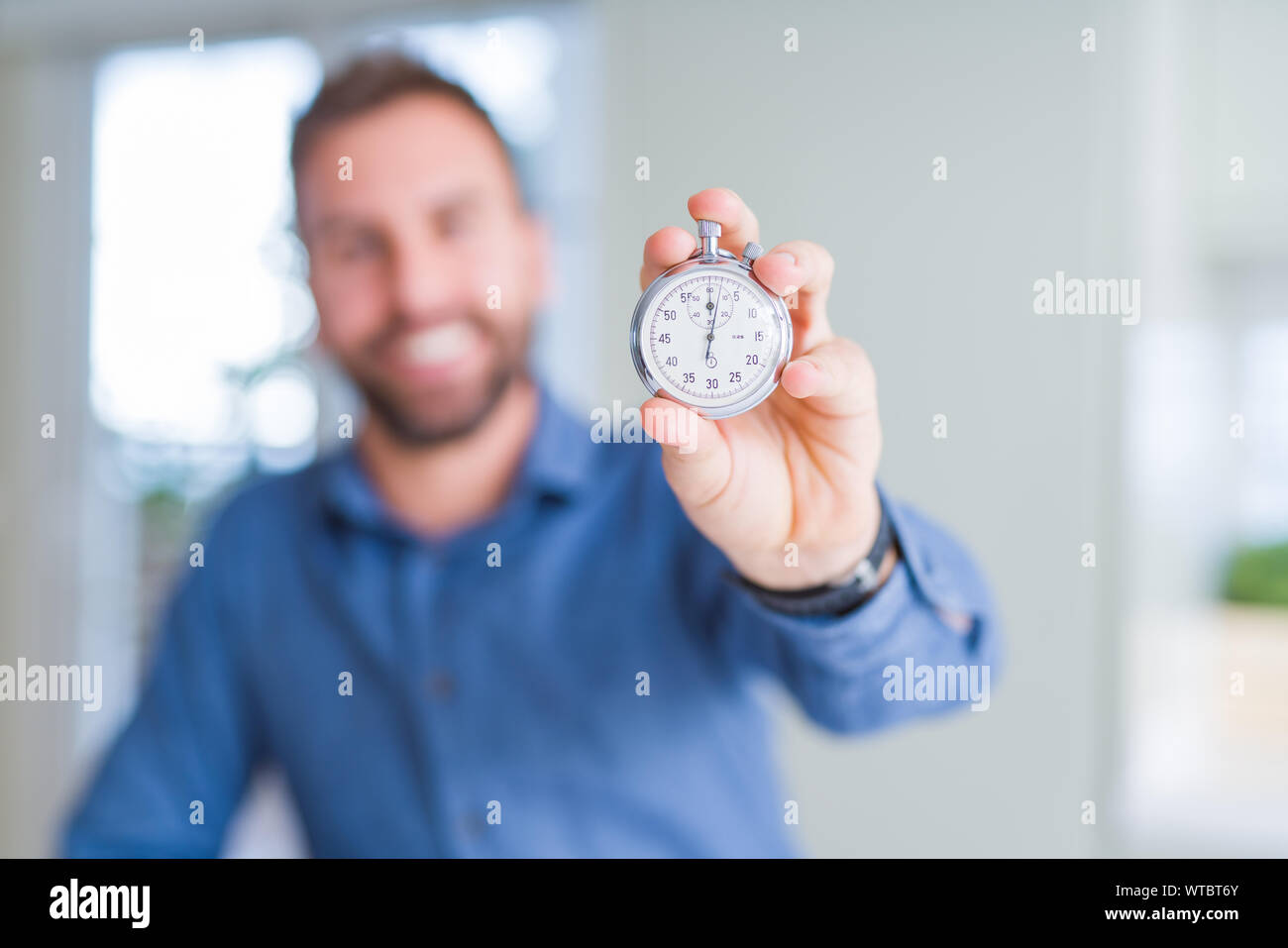 Handsome man showing stopwatch Stock Photo - Alamy