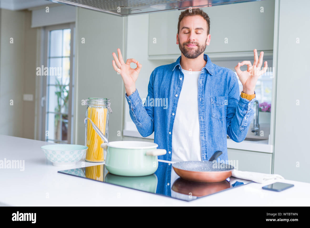 Handsome man cooking italian spaghetti pasta at the kitchen relax and ...