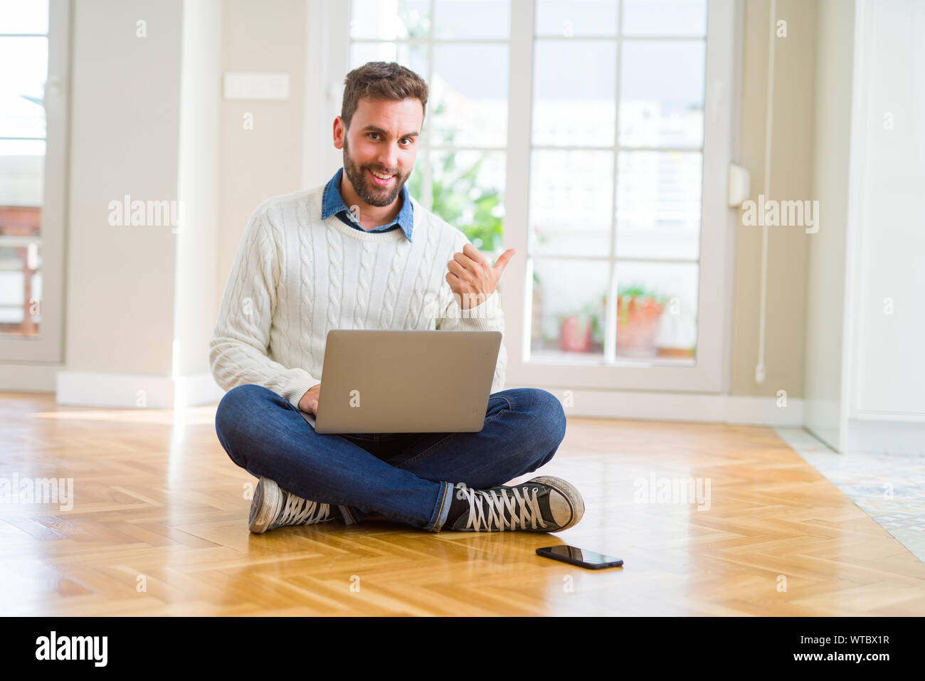 Handsome man wearing working using computer laptop pointing and showing ...