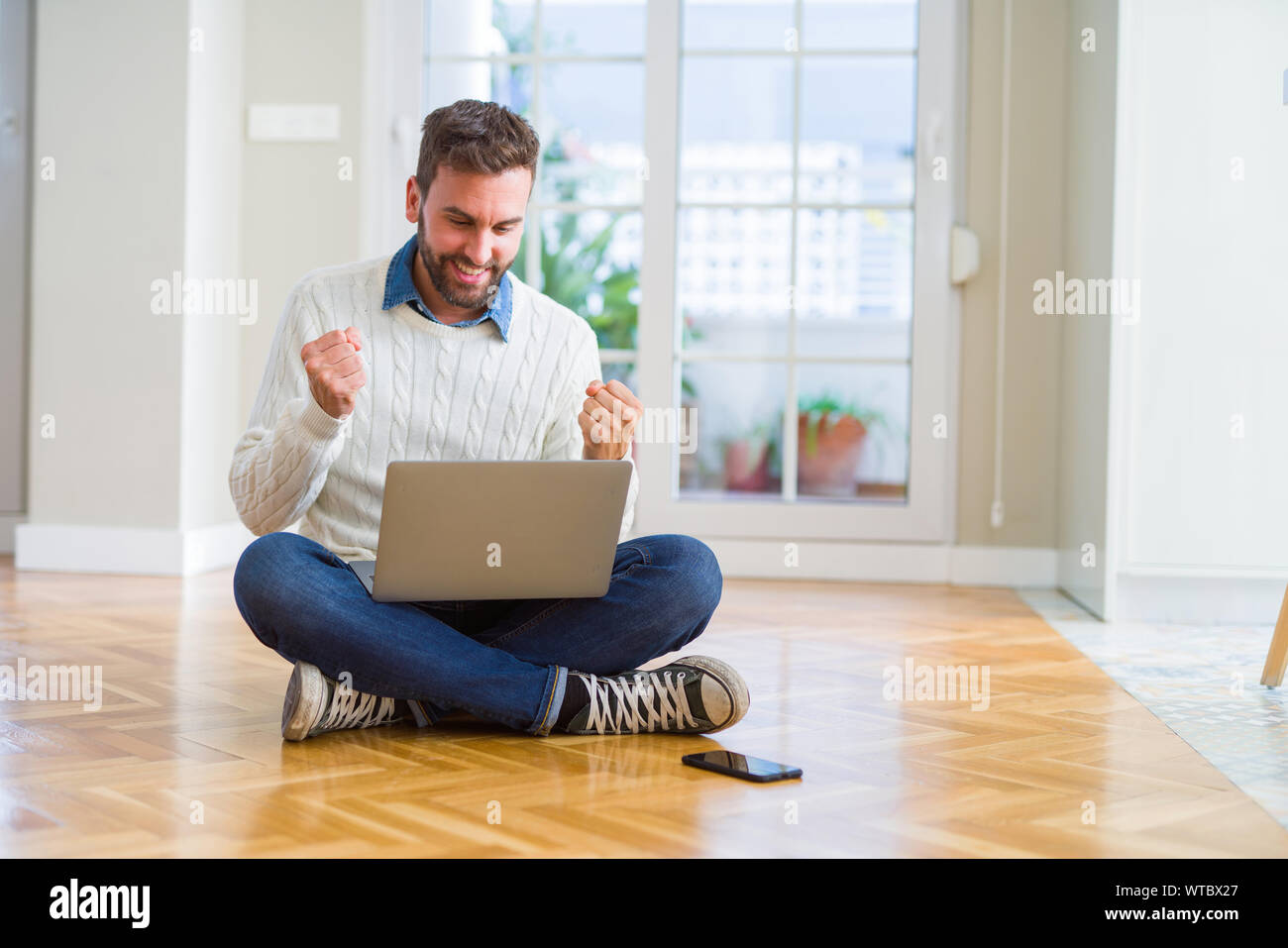 Handsome man wearing working using computer laptop screaming proud and ...