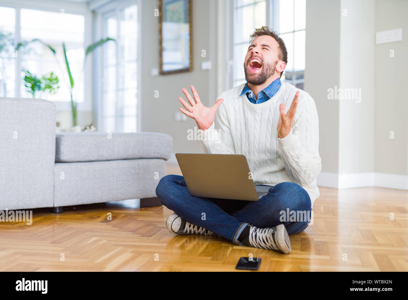 Handsome man wearing working using computer laptop celebrating mad and ...