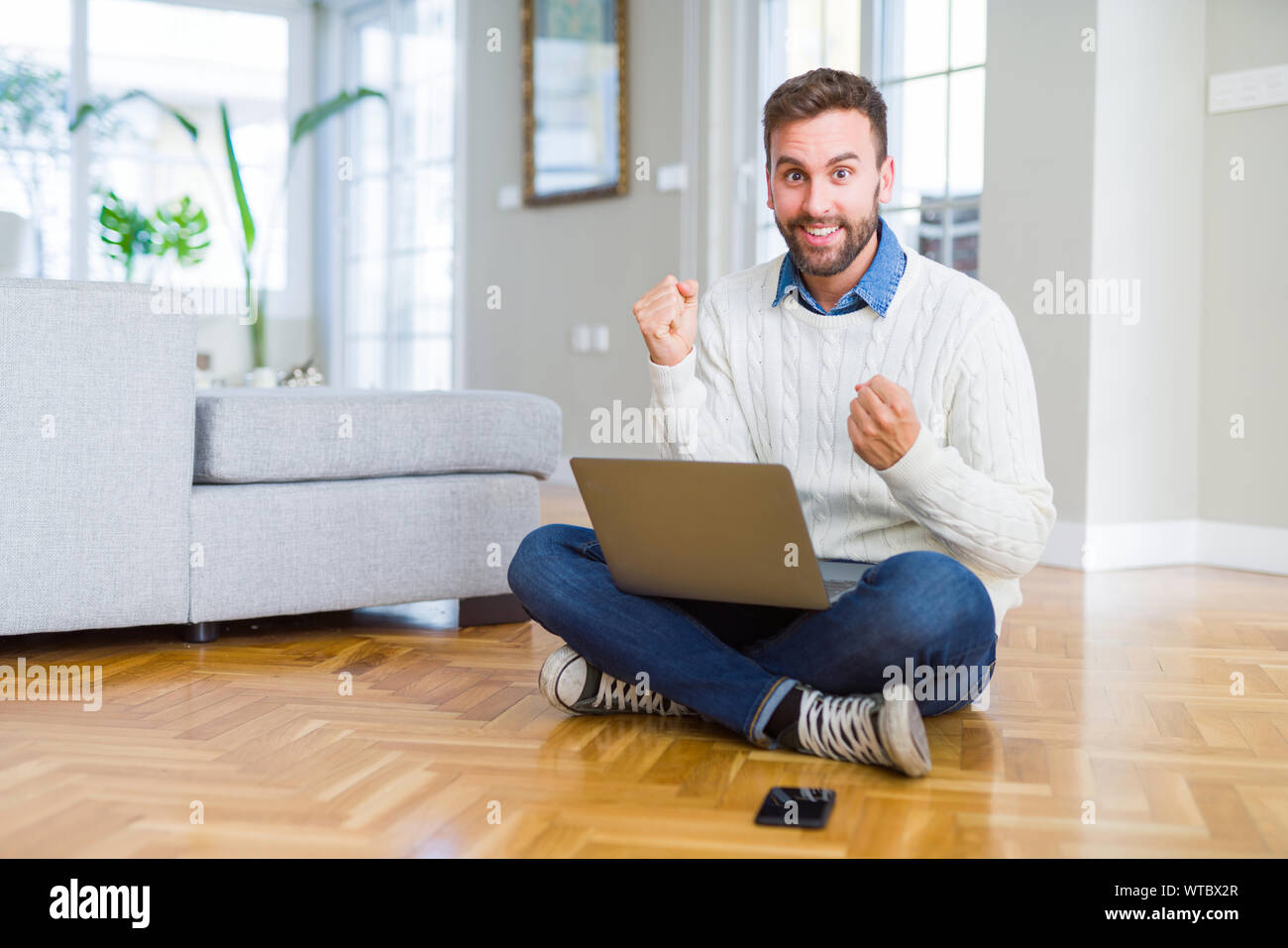 Handsome man wearing working using computer laptop celebrating ...