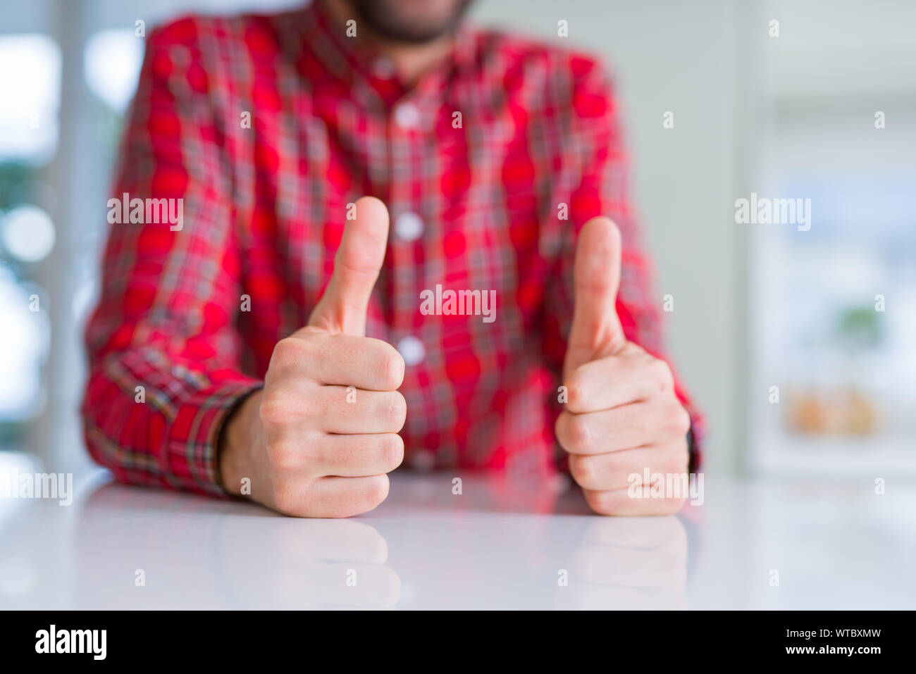 Close up of hands man doing thumbs up gesture over white table Stock ...