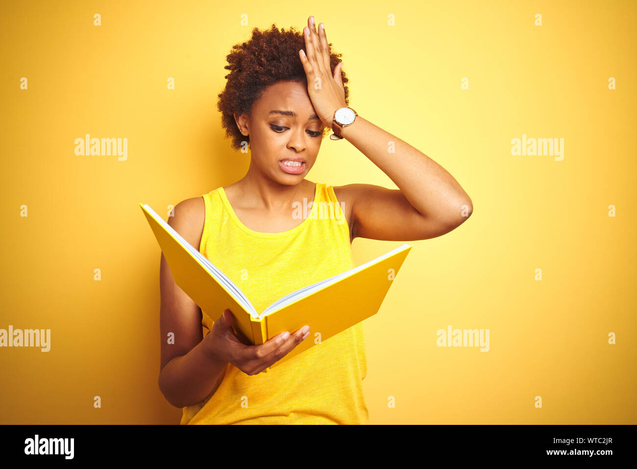 African american woman reading a book over yellow isolated background ...