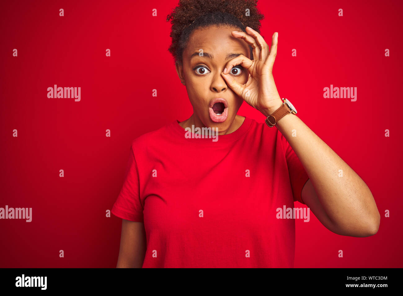 Young beautiful african american woman with afro hair over isolated red ...