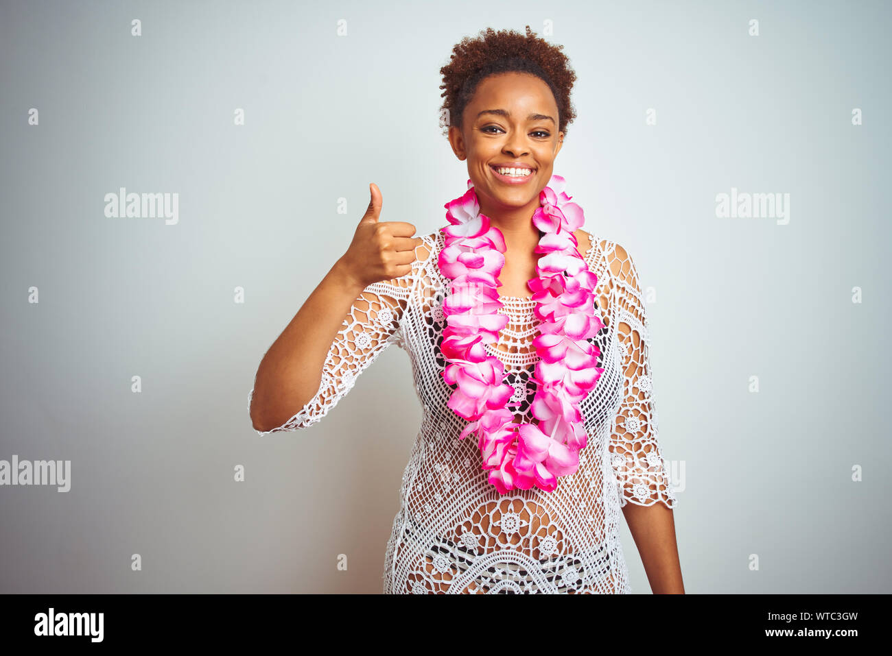 Young african american woman with afro hair wearing flower hawaiian lei ...