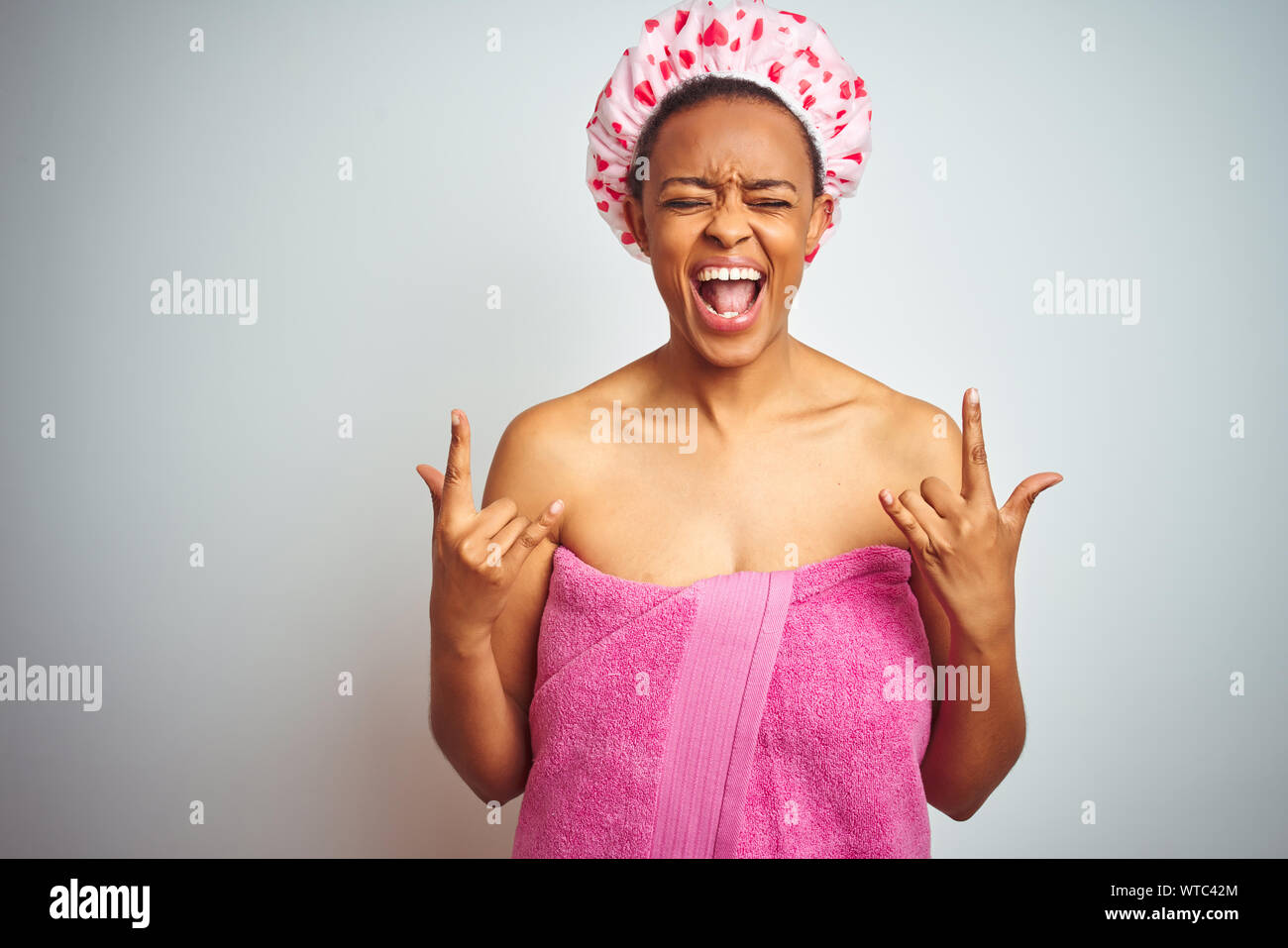 African american woman wearing pink shower towel after bath over ...