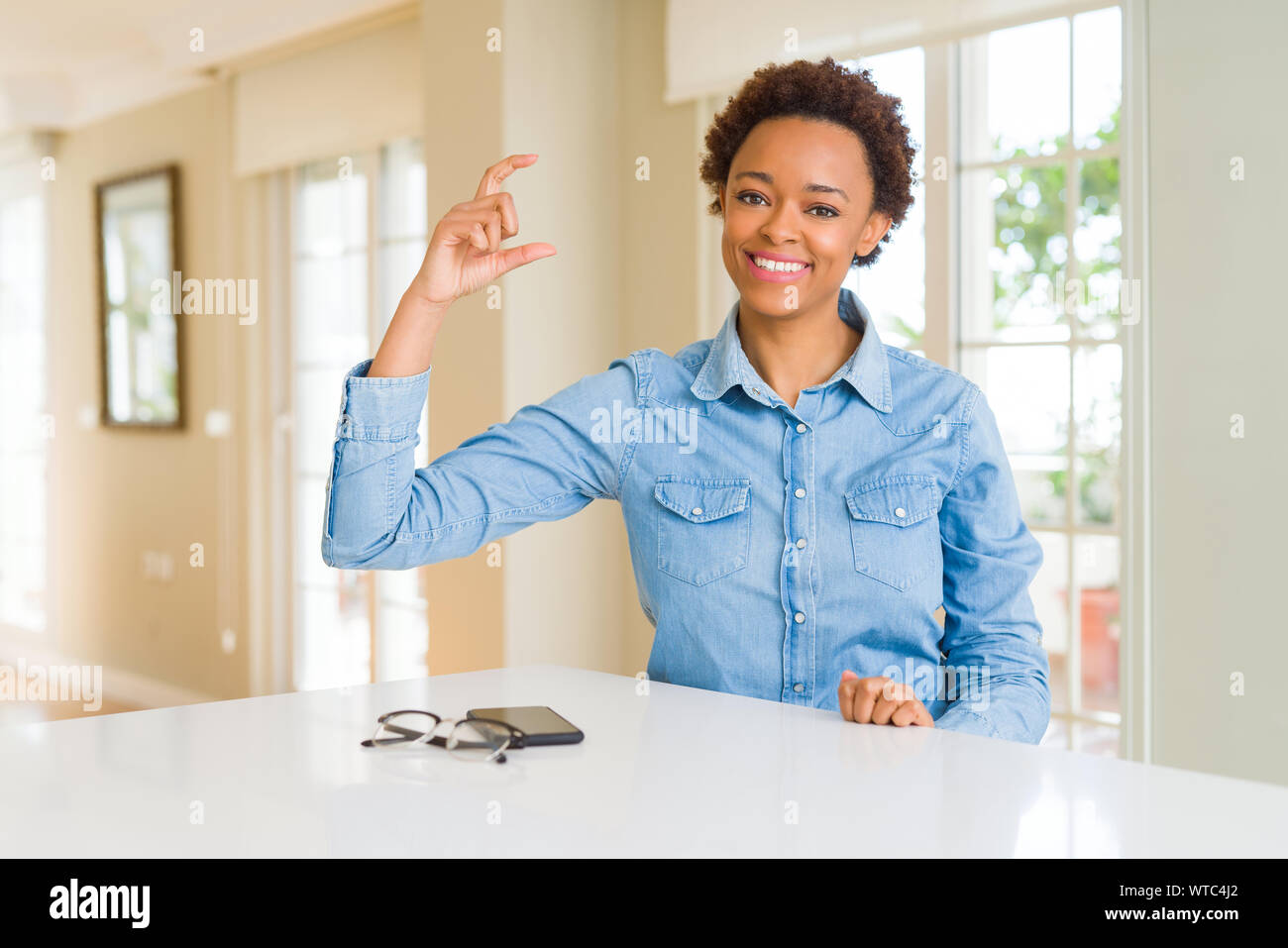 Young beautiful african american woman smiling and confident gesturing ...
