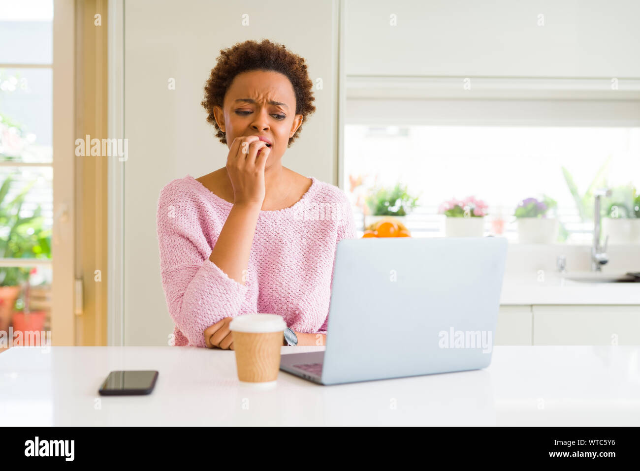 Young african american woman working using computer laptop looking ...