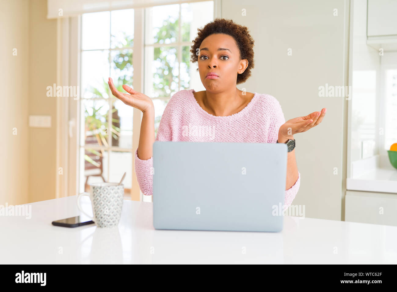 Young african american woman working using computer laptop clueless and ...