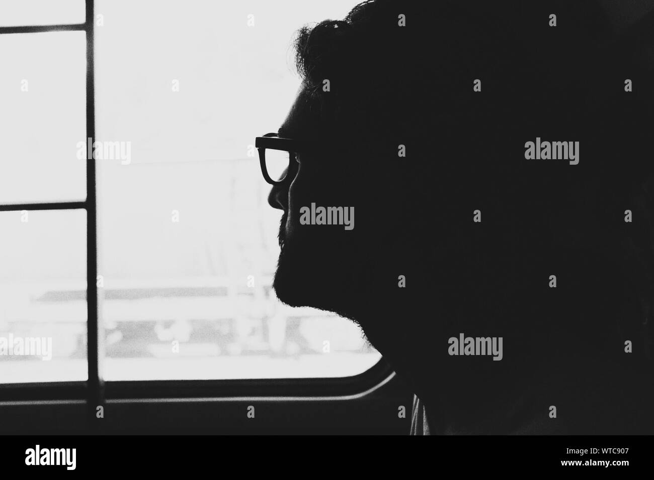 Man looking through window Black and White Stock Photos & Images - Alamy
