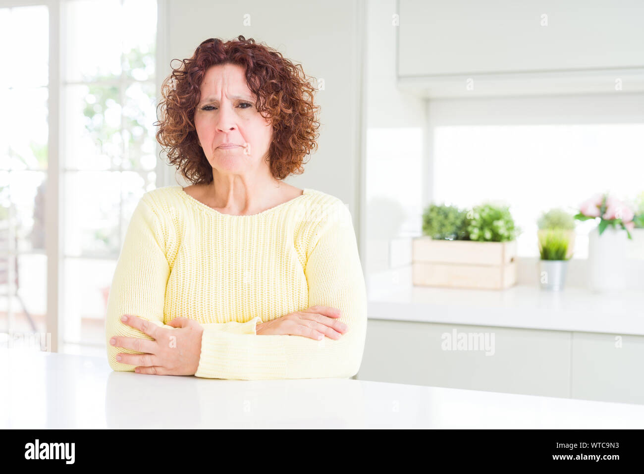 Beautiful senior woman wearing yellow sweater skeptic and nervous ...