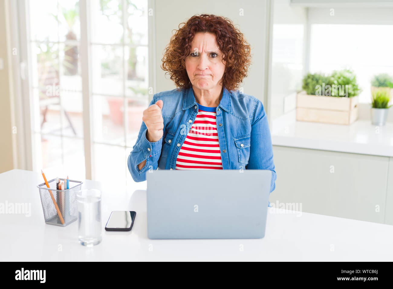 Senior woman working using computer laptop annoyed and frustrated ...