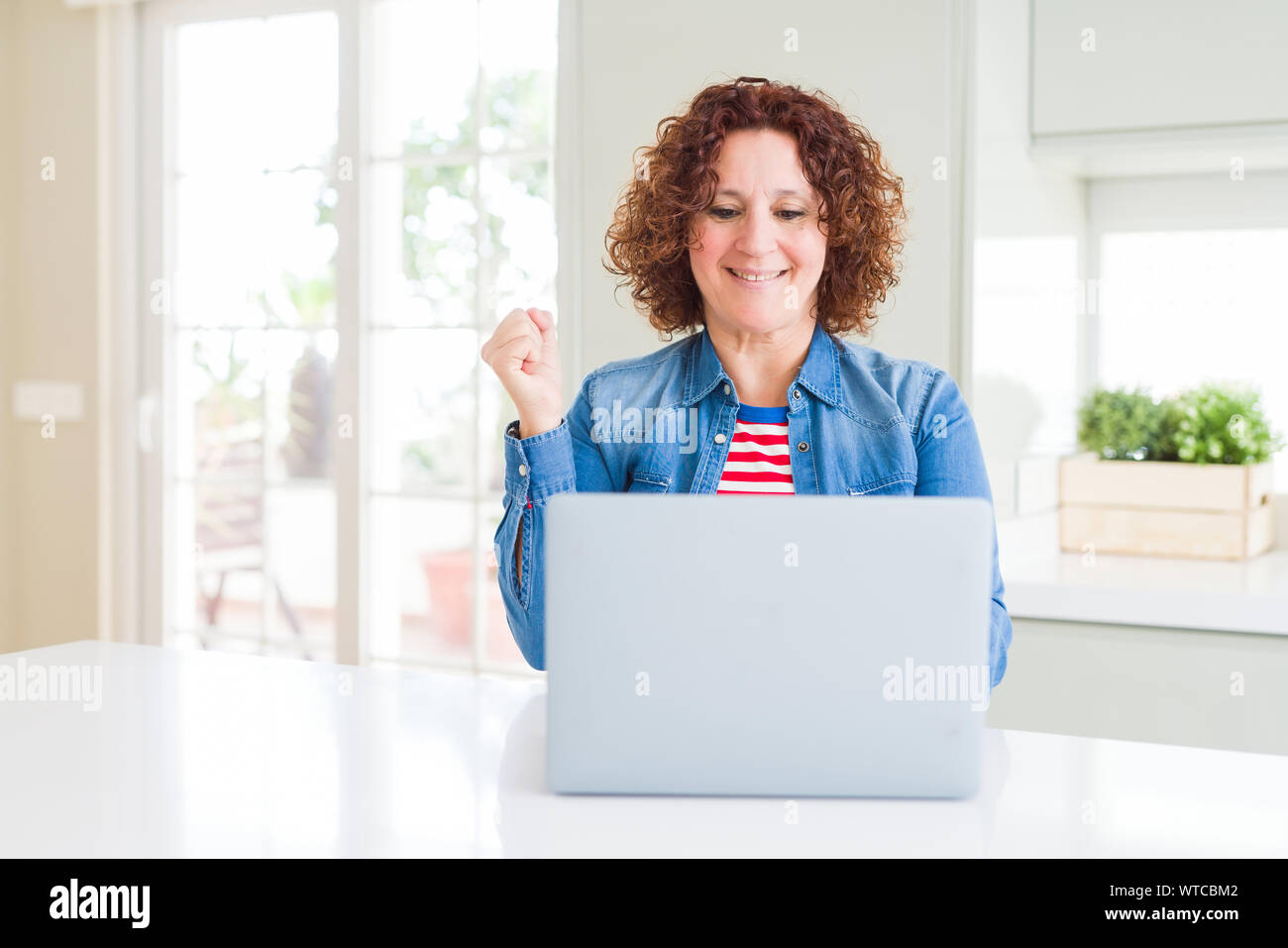 Senior woman working using computer laptop screaming proud and ...