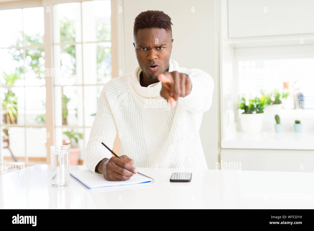 African american student man writing on a paper using a pencil pointing ...