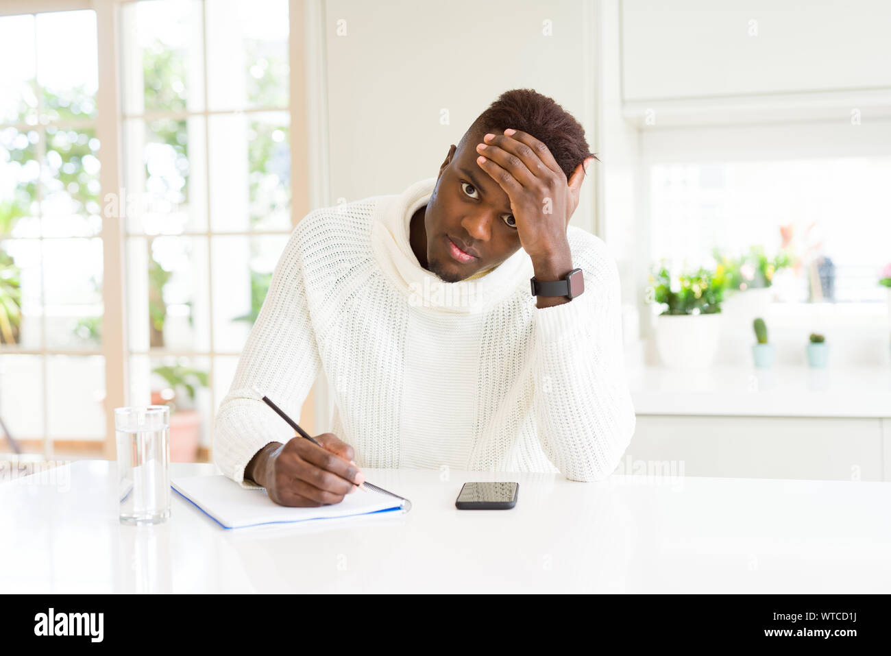African american student man writing on a paper using a pencil stressed ...