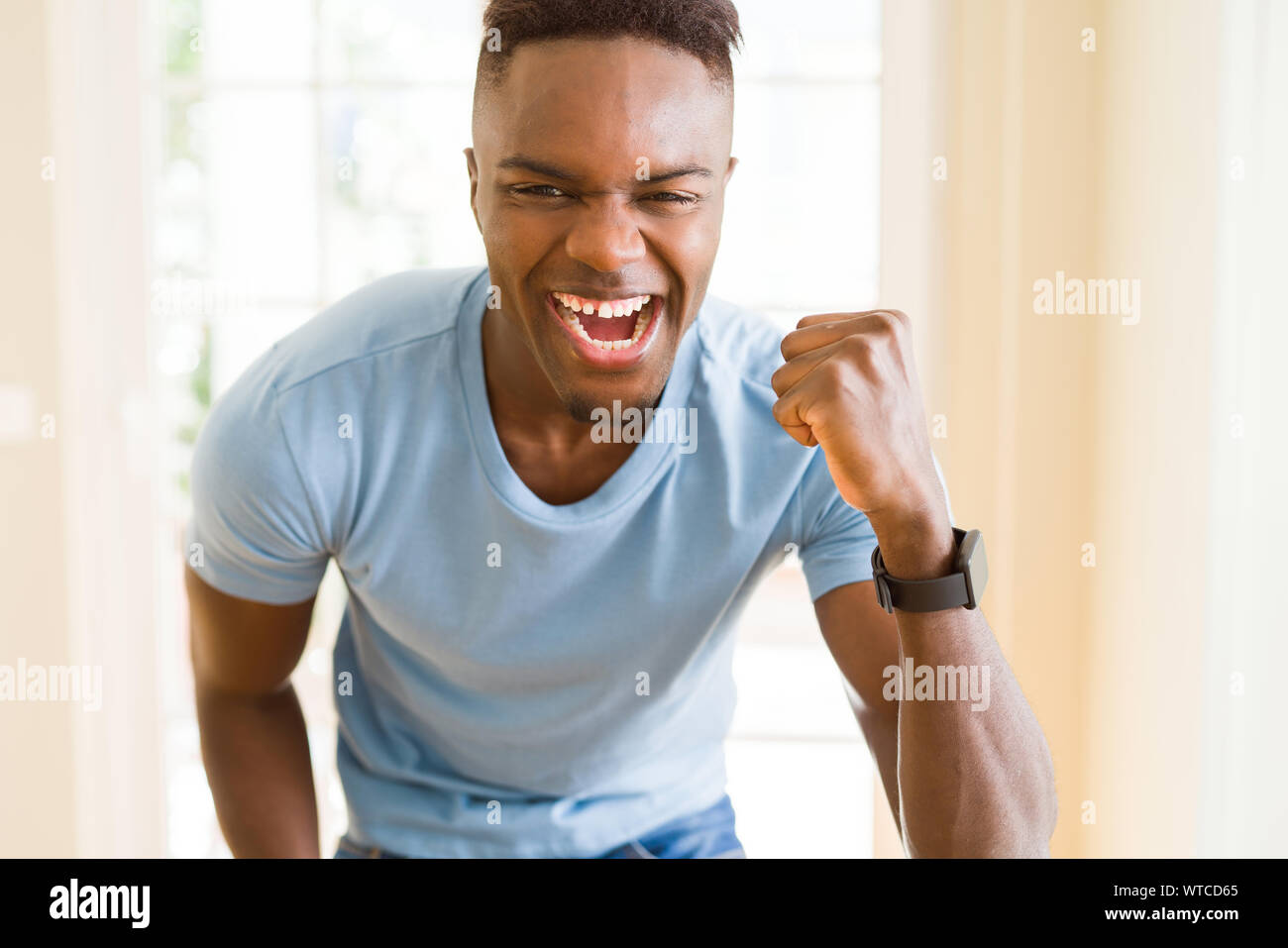 African American man screaming very excited and celebrating success and ...